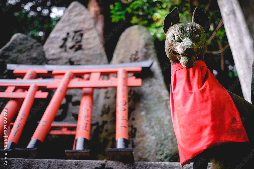Fox (kitsune) stone statue and torii gates at sanctuary in Fushimi ...