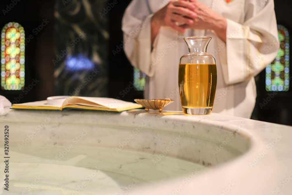 Priest in front of a baptismal font with a bible. Baptism scene. Priest ...