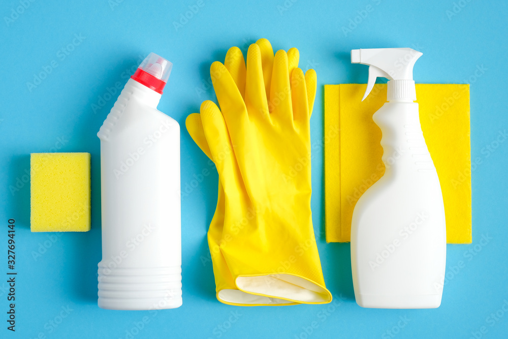 Set of cleaning supplies on blue background. Flat lay yellow rag and ...