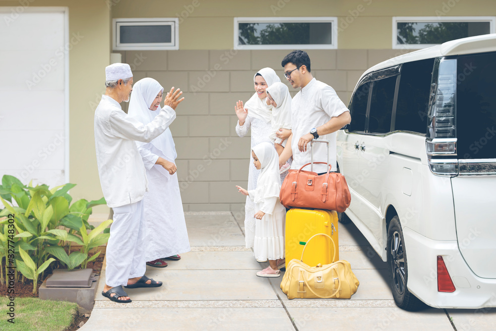 Young muslim family with daughter waving hands saying goodbye to ...