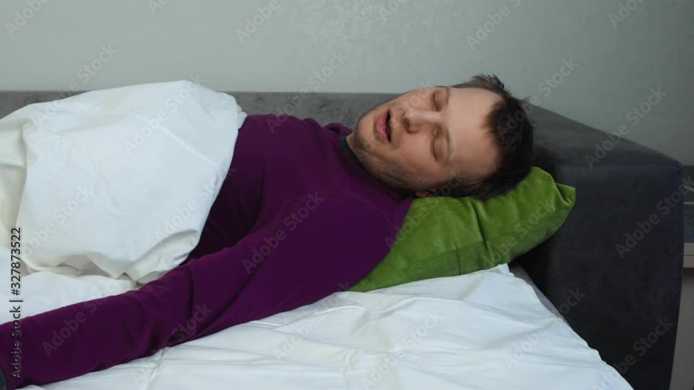Man sleeps, then he wakes up abruptly, rises, pillow flies into him and ...
