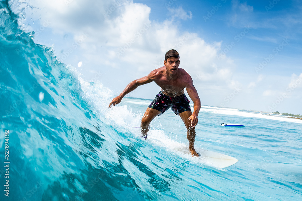 Young athletic surfer rides the ocean wave on Sultans surf spot in ...