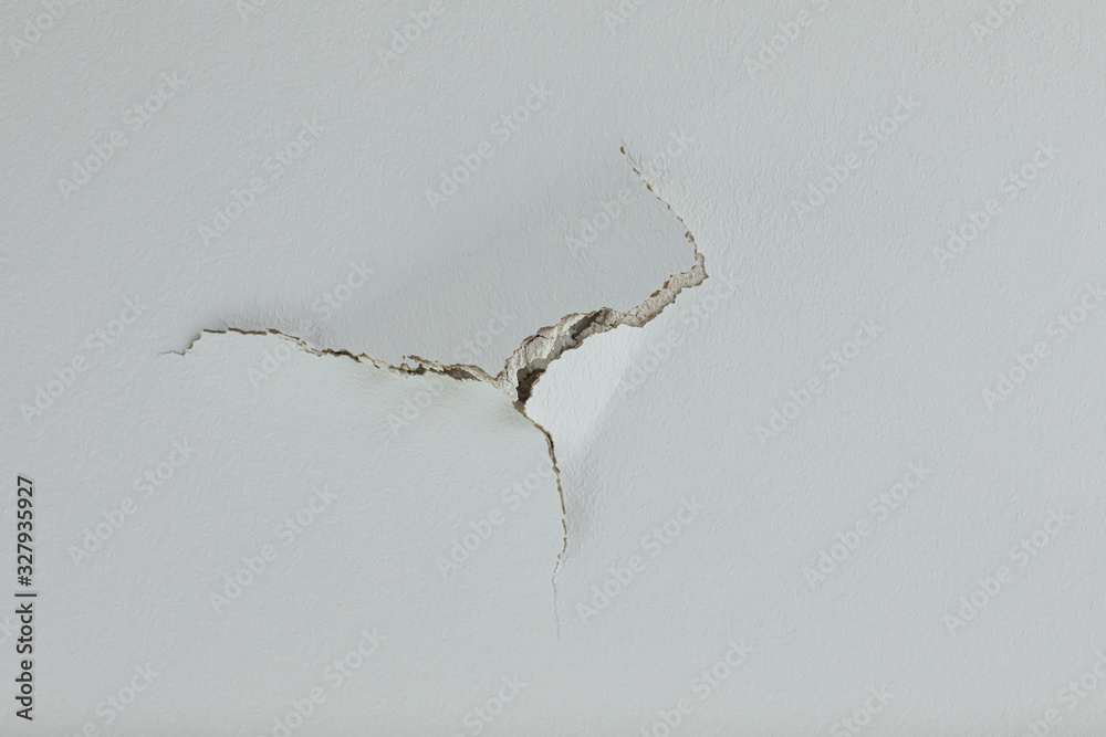 Puncture crack hold in ceiling wall of white painrtd drywall Stock ...
