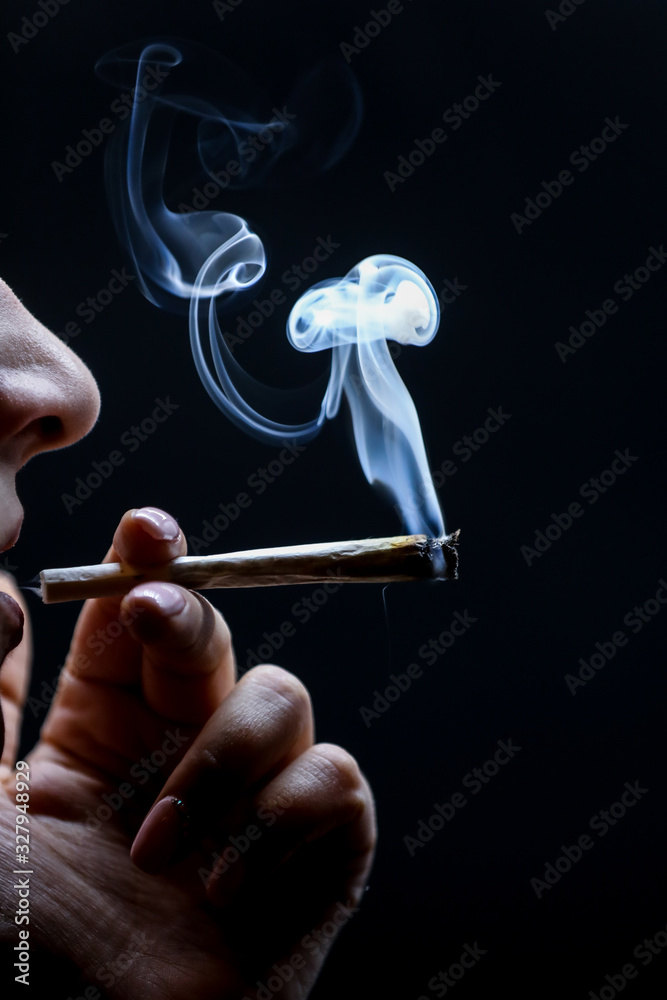 Woman hand holding cigarette. Smoking cannabis joint. Medical use ...