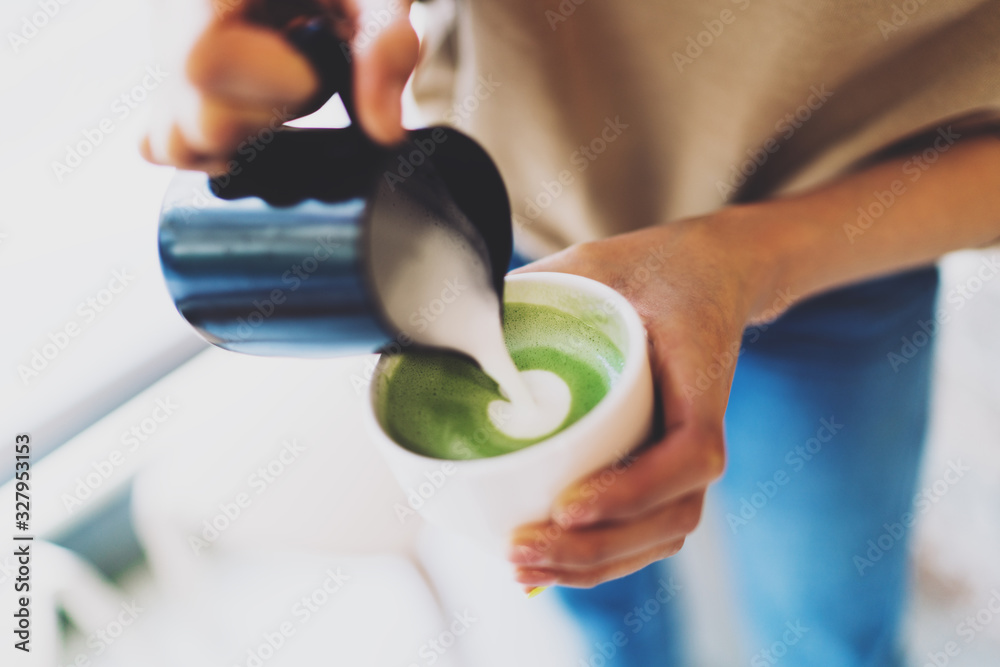 Professional female barista adding whipped milk to a freshly made ...