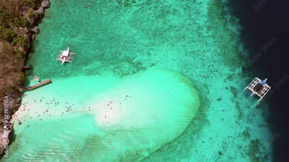 Aerial view of the Sumilon island, sandy beach with tourists swimming ...