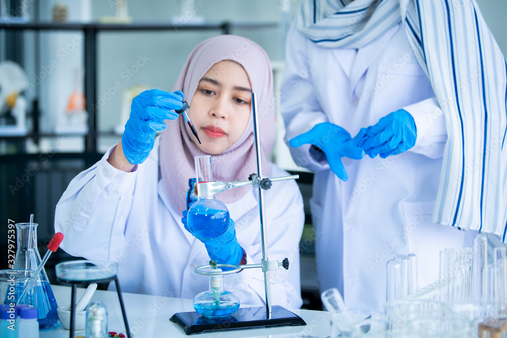 Happy Asian muslim scientist student investigating a chemistry together ...