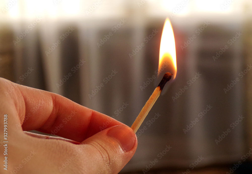 Hand holding a burning match. Match with fire and flame on a dark ...