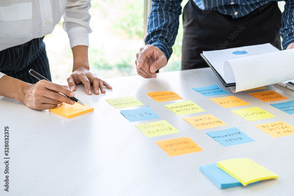 Two creative business people meeting and planning use post it notes ...