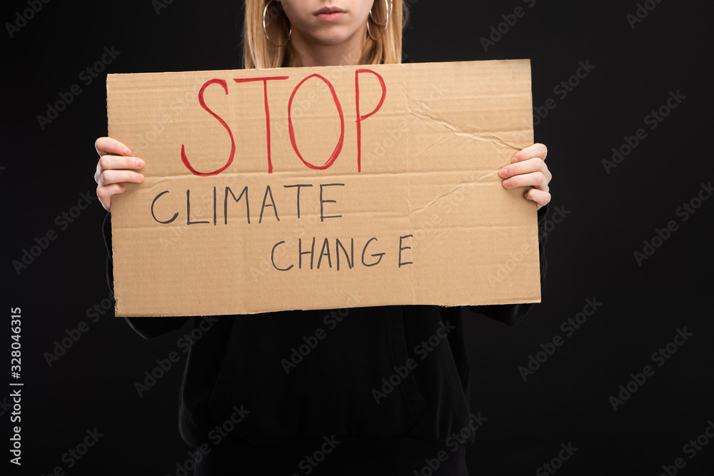 Partial view of blonde woman with placard with stop climate change ...