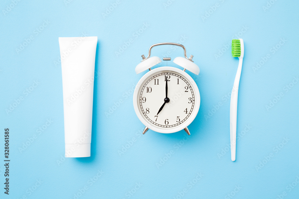 Alarm clock, toothbrush with green bristles and white tube of ...
