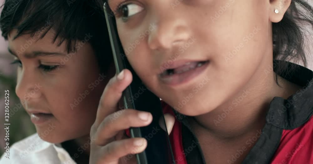 Friends like siblings using a smart phone mobile device to talk and ...