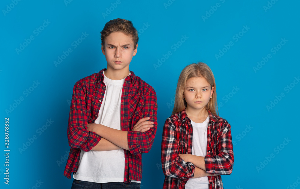 Siblings Conflicts. Frowning Little Brother And Sister Standing With ...
