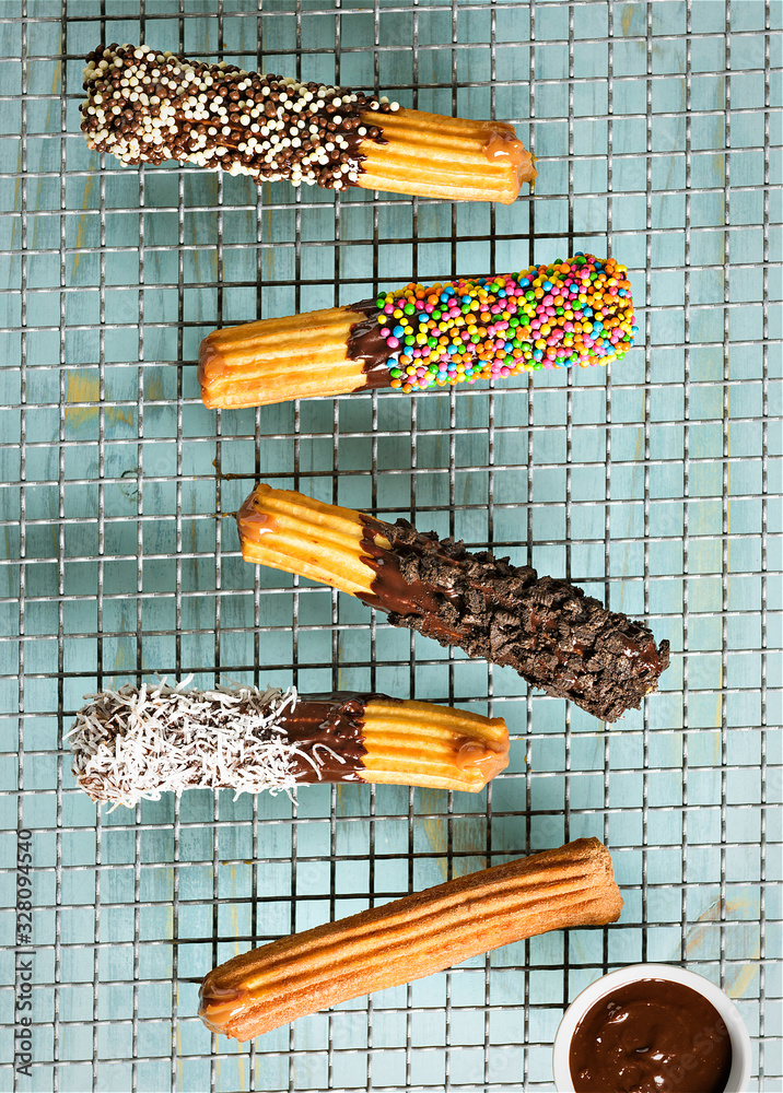 Five delicious churros on a grill, with different types of coverage ...
