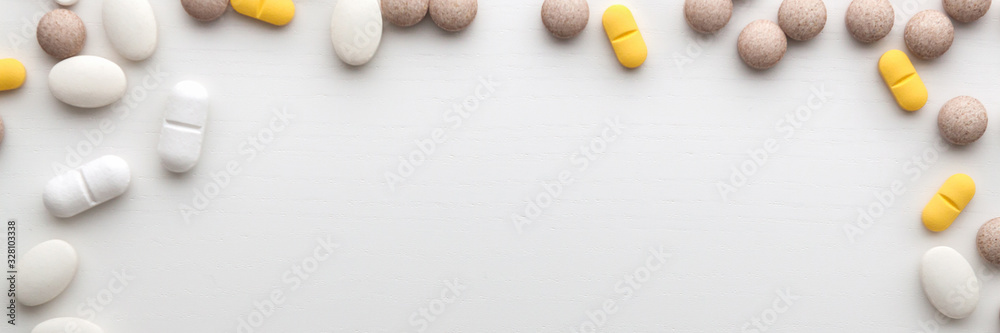 Tablets on a white wooden table. Pharmacy and pharmacology. Top view ...