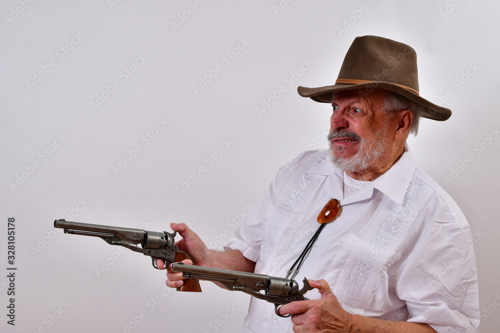 Angry old man aims two revolvers..Elderly gentleman with floppy hat and ...