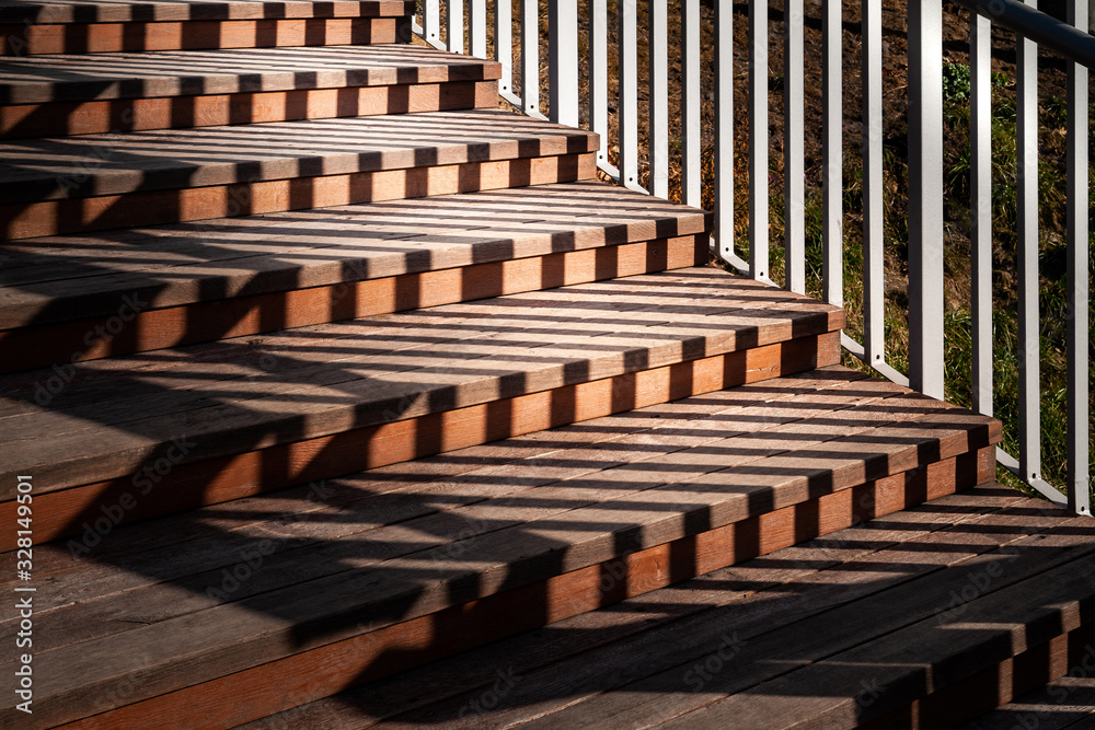 Staircase with a shadow from the railing. A staircase descending with ...