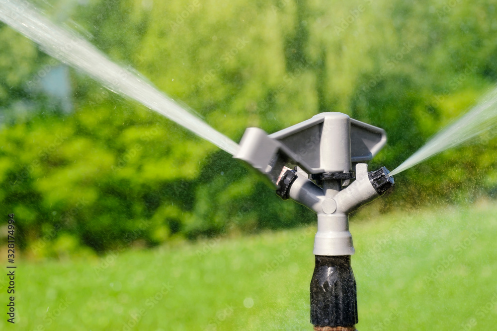 Automatic lawn grass irrigation system in park. Splashing spraying ...