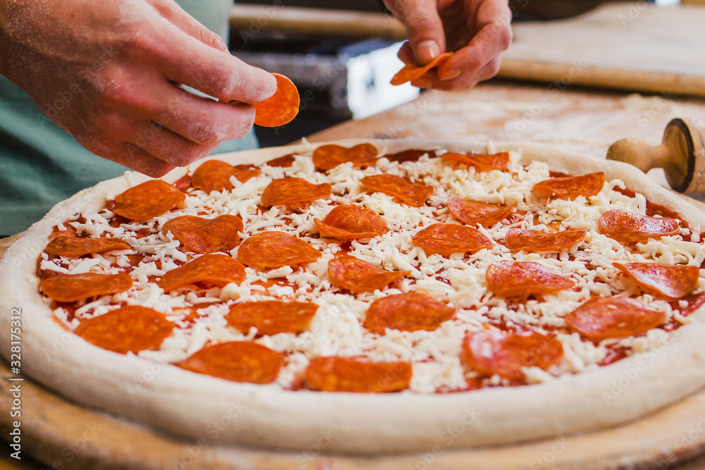 Hands preparing a pizza or making a Homemade Pepperoni Pizza Stock ...