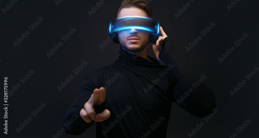 Guy using VR helmet scrolling invisible screen while interacting with ...