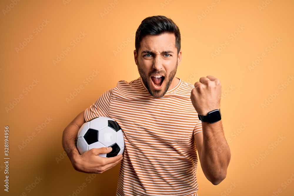 Handsome player man with beard playing soccer holding footballl ball ...