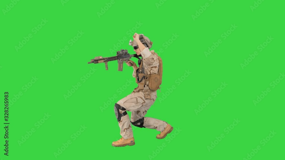 Soldier walking aiming with rifle and using radio on a Green Screen ...