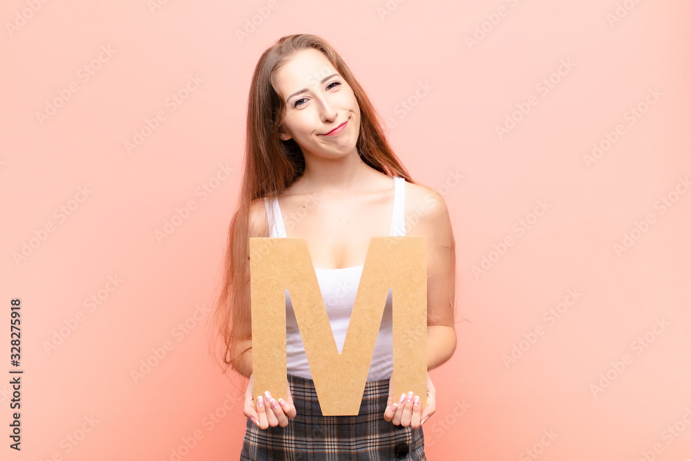 yound blonde woman angry, anger, disagreement, holding the letter M of ...