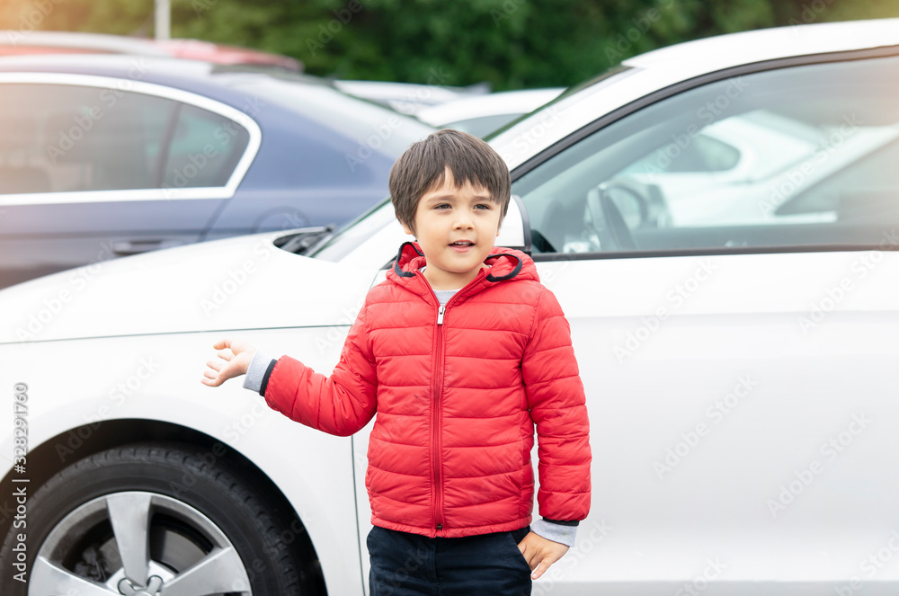 Outdoor portrait preschool kid boy with a smiling face standing next to ...
