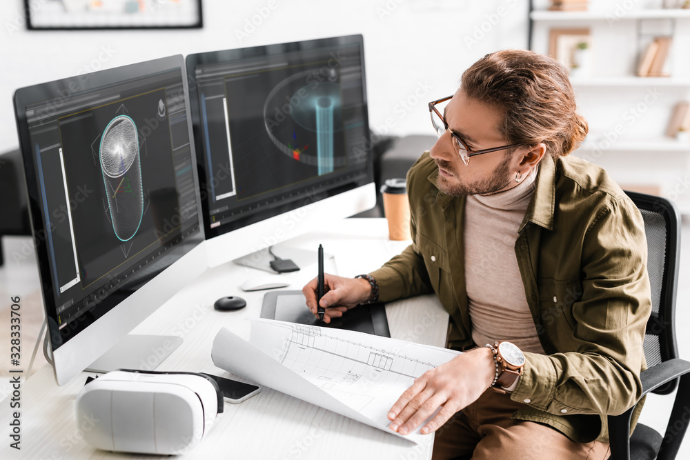 3d artist using blueprint with graphics tablet and computers while ...
