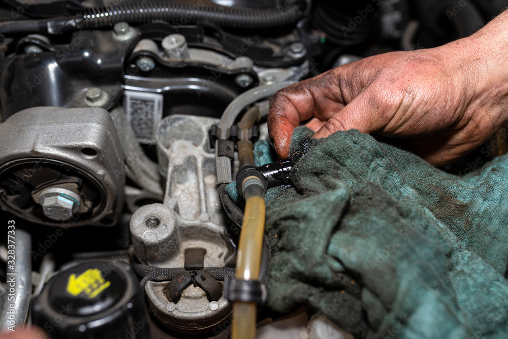 The mechanic bleeds the fuel system with a pump that is on the fuel ...