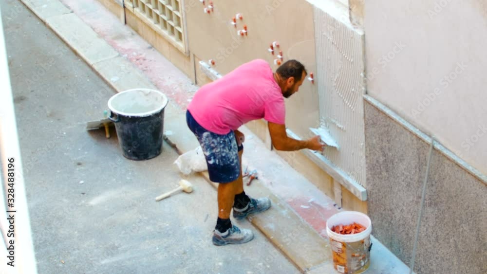 Worker labor building wall and UPVC groove line with plaster cement at ...