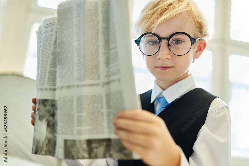 Child as a businessman with a daily newspaper Stock Photo | Adobe Stock