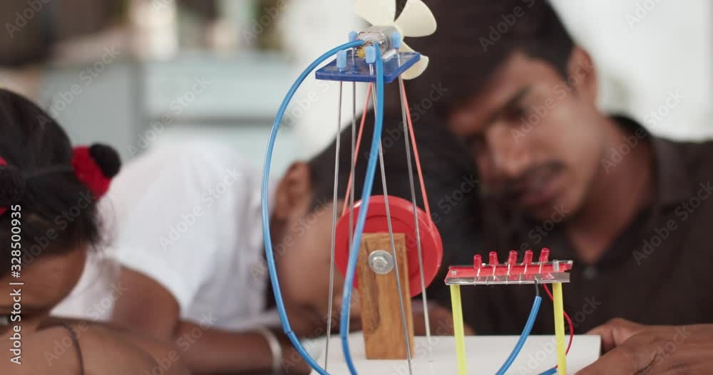 Closeup of kids learning with teacher to generate electricity on leds ...