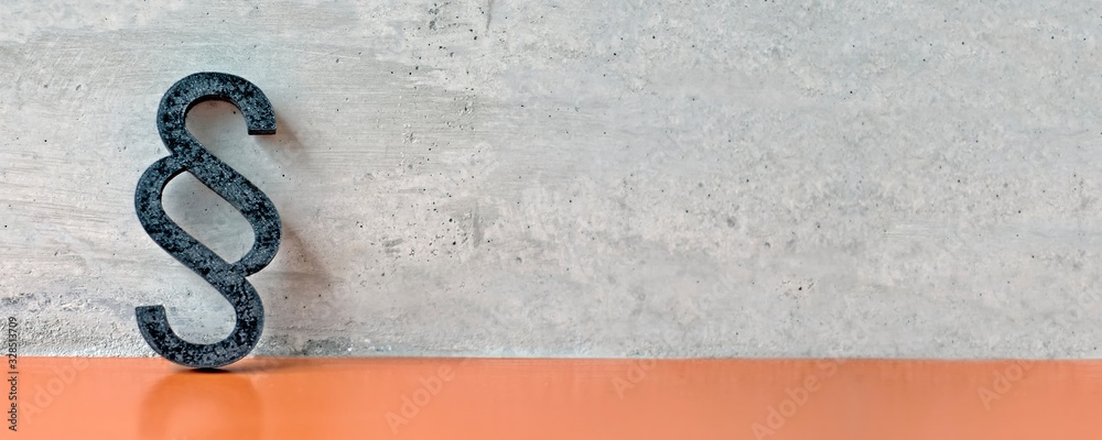 Paragraph / section sign in front of a concrete wall. Panoramic image ...