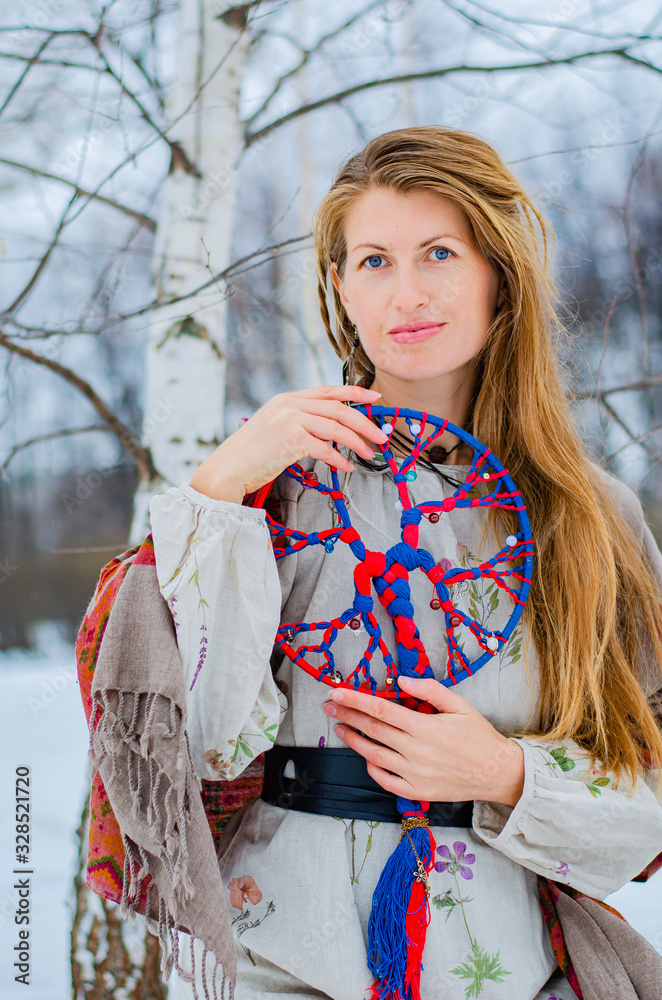 A young blonde woman in traditional Slavic clothing holds the symbol of ...