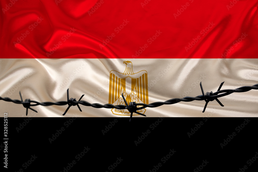 iron barbed wire against the background of the national silk flag of ...