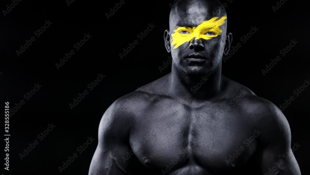 Man sports fan and bodybuilder athlete with yellow color on face art ...