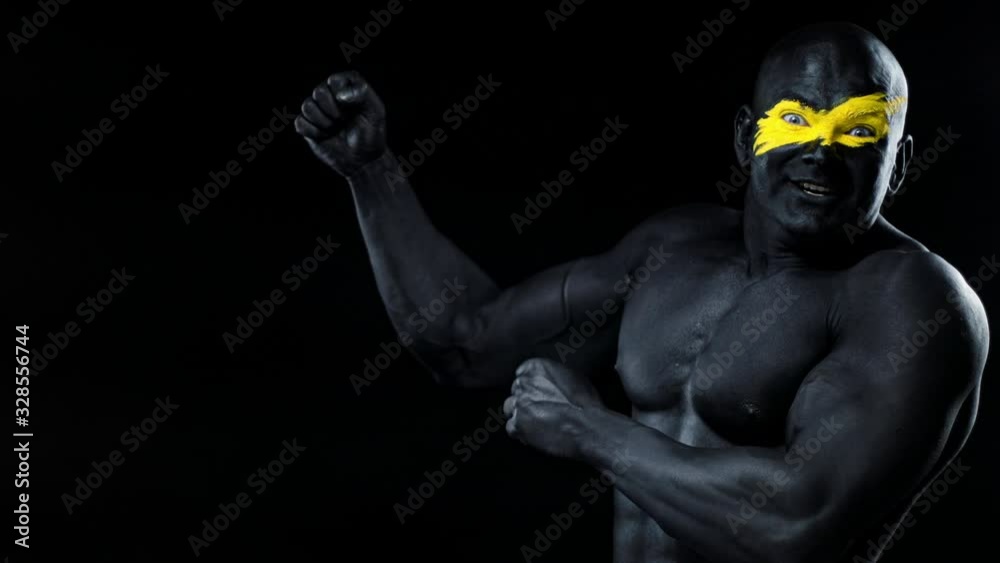Man pick on copy space. Bodybuilder athlete with yellow face art and ...