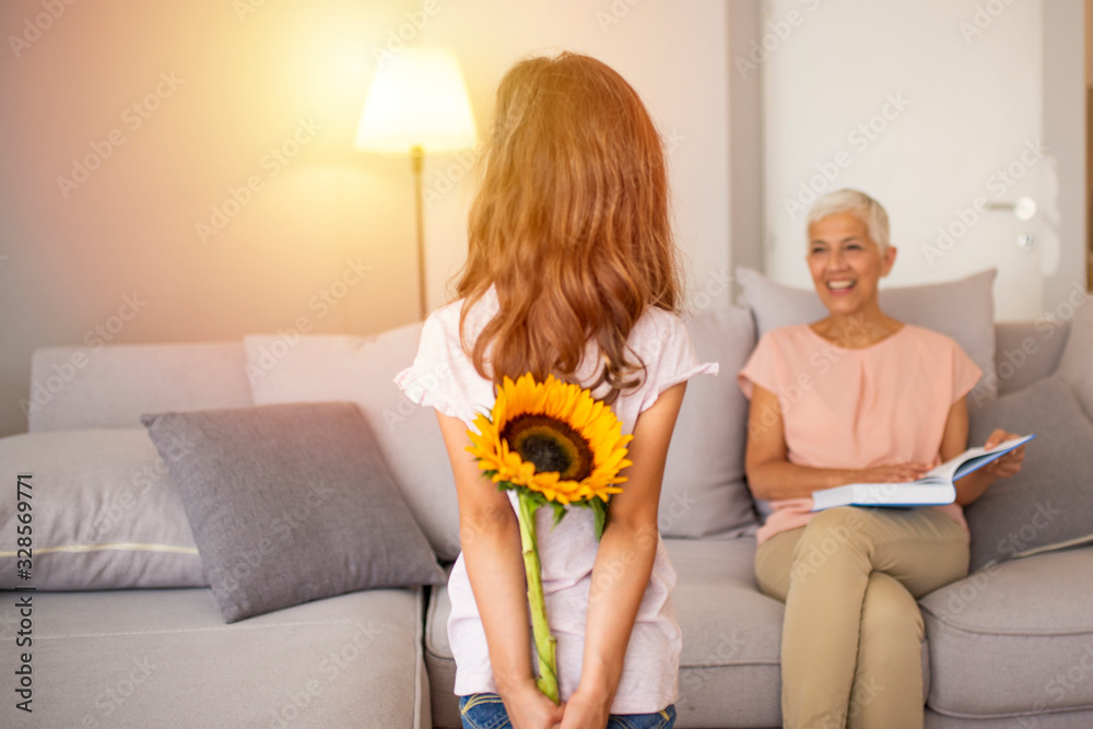 Rear view portrait of cute little girl holding bouquet behind back ...