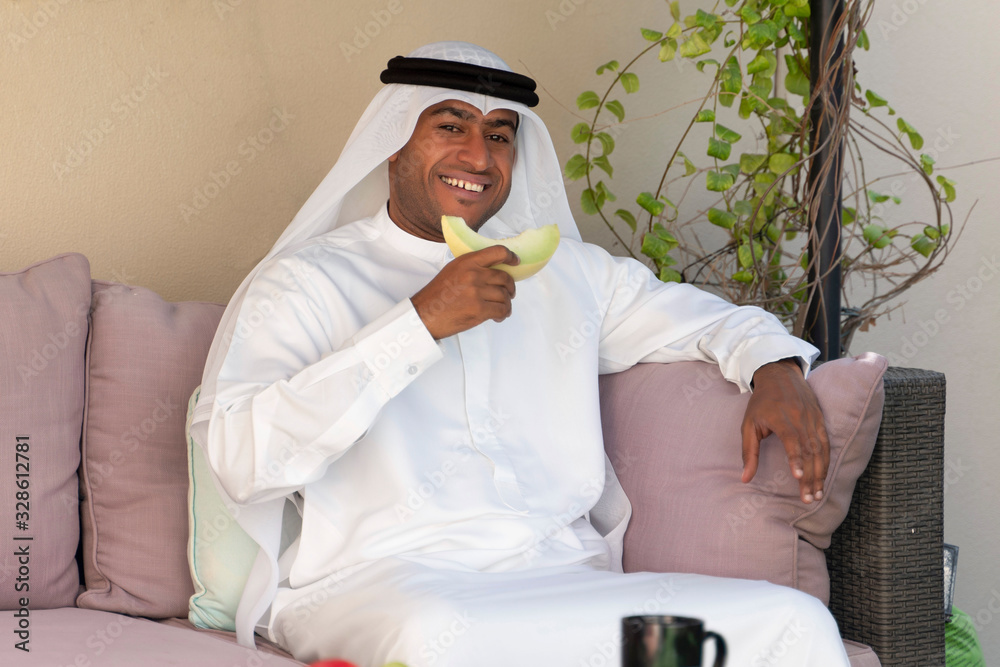 Happy, handsome Emirati man wearing traditional kandura or thobe ...