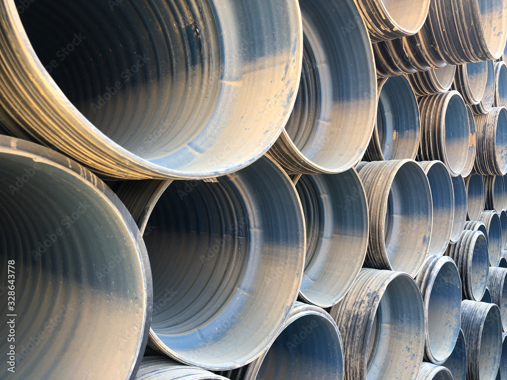 Stacked corrugated pvc-pipes at the outdoor warehouse. Drainage ...