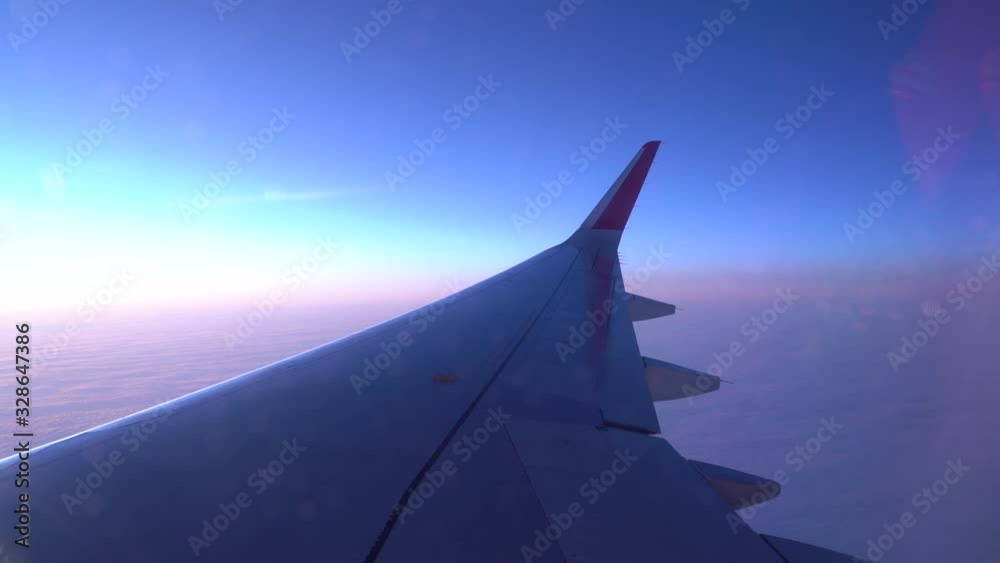 Through the porthole, you can see the wing of the aircraft , which is ...