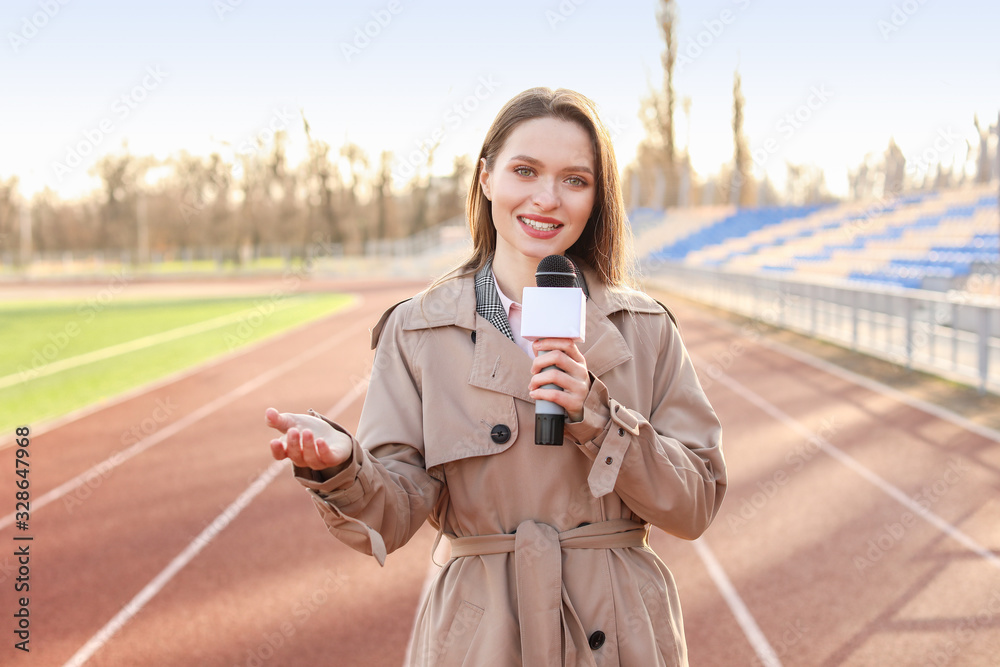 Beautiful reporter with microphone at the stadium Stock Photo | Adobe Stock