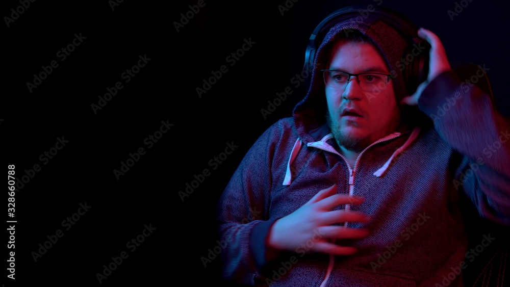 A young man sits at a computer and gets scared. The man in the hood ...