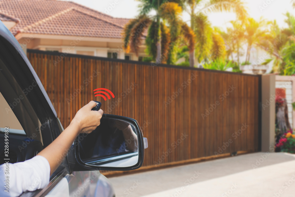 Woman inside car, hand holding and using remote control to open the ...