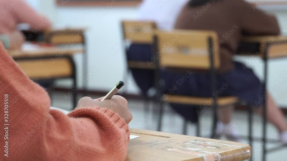 Exam classroom of students group hands holding fill in carbon paper ...
