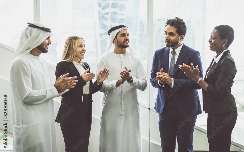 Mixed business team in Dubai. Business meeting with men wearing kandura ...