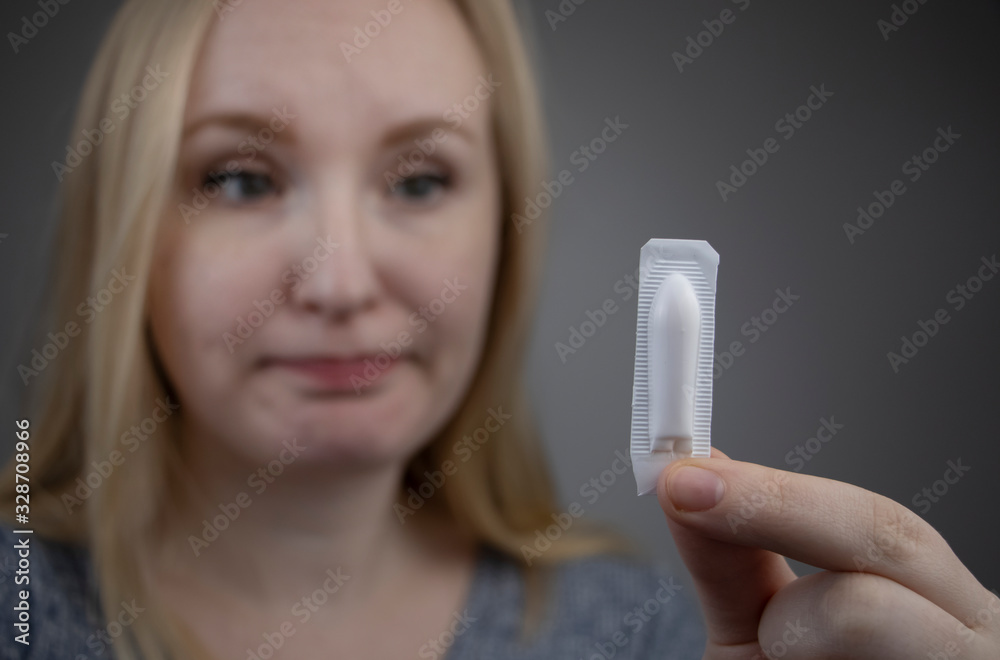 Vaginal or rectal suppository in the hands of a woman. The drug is in ...