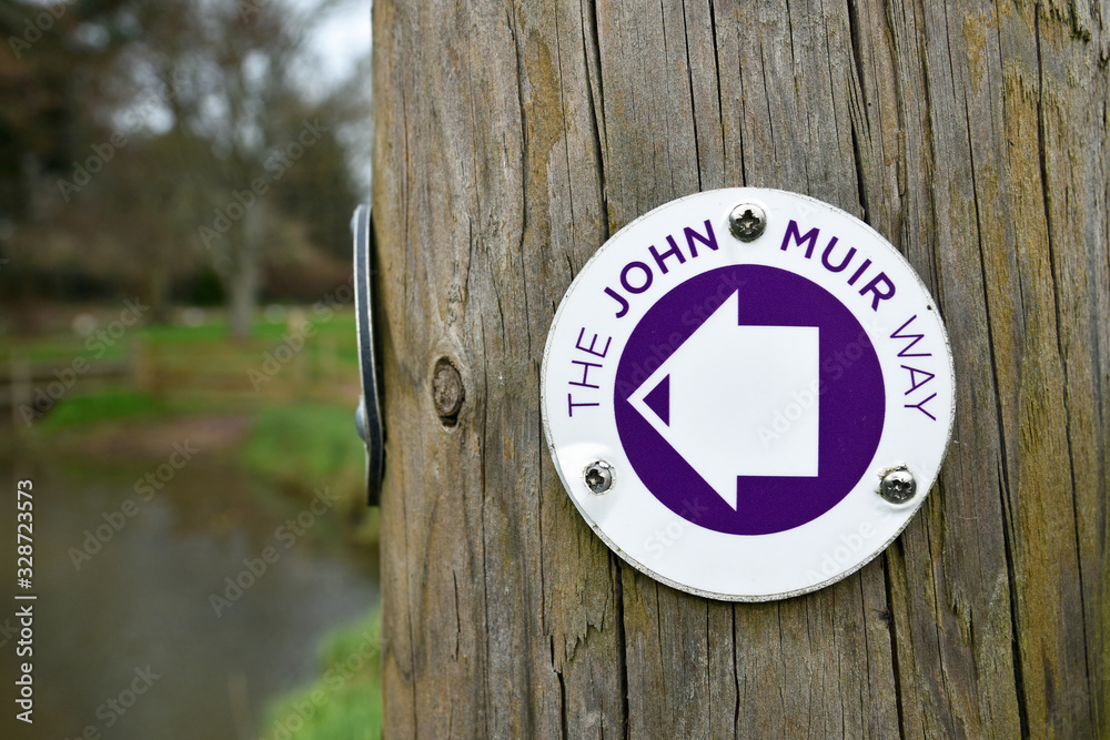 Sign for John Muir Way in Scotland with blurred background of grass and ...