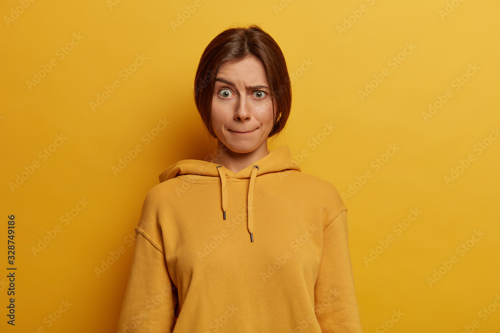 Beautiful dark haired young European woman presses lips, raises ...